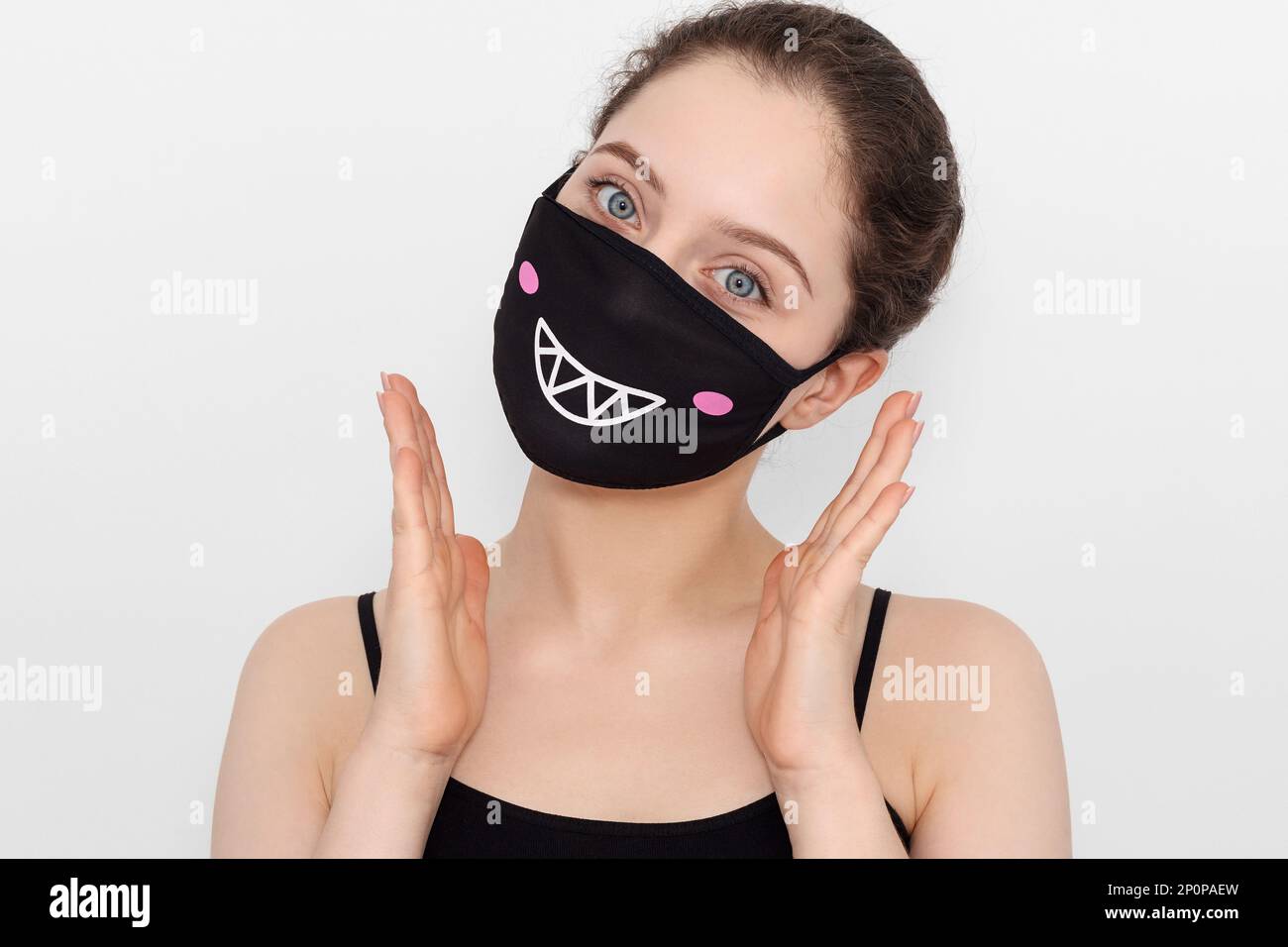 Young girl in a reusable mask with a print, in a black t-shirt on a ...