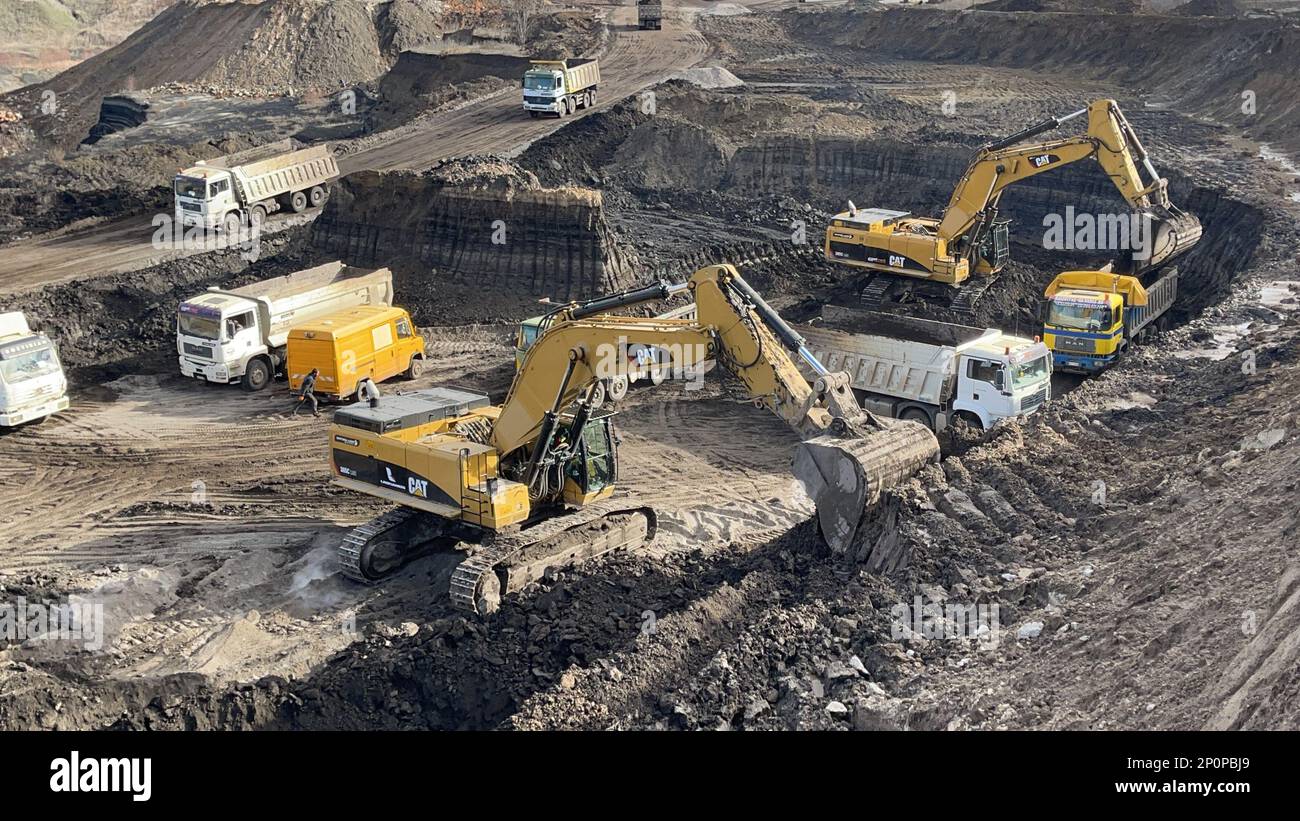 Excavators are loading continuously the trucks, working at a huge ...