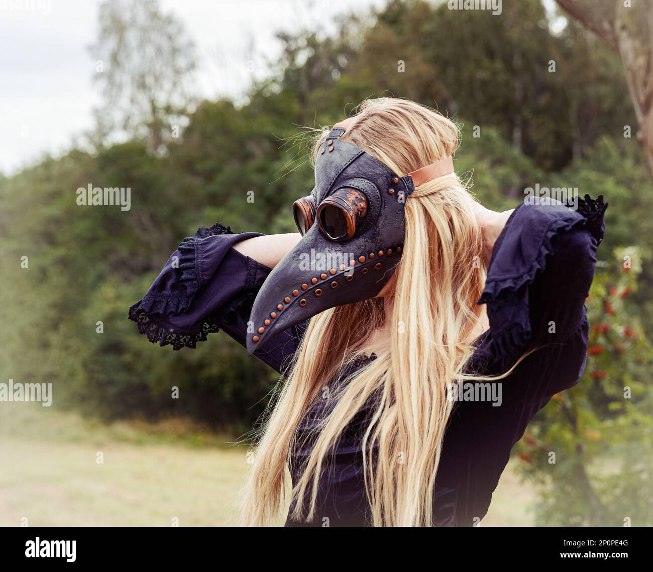 An eerie and surreal photo of a woman in a crow mask standing in a ...