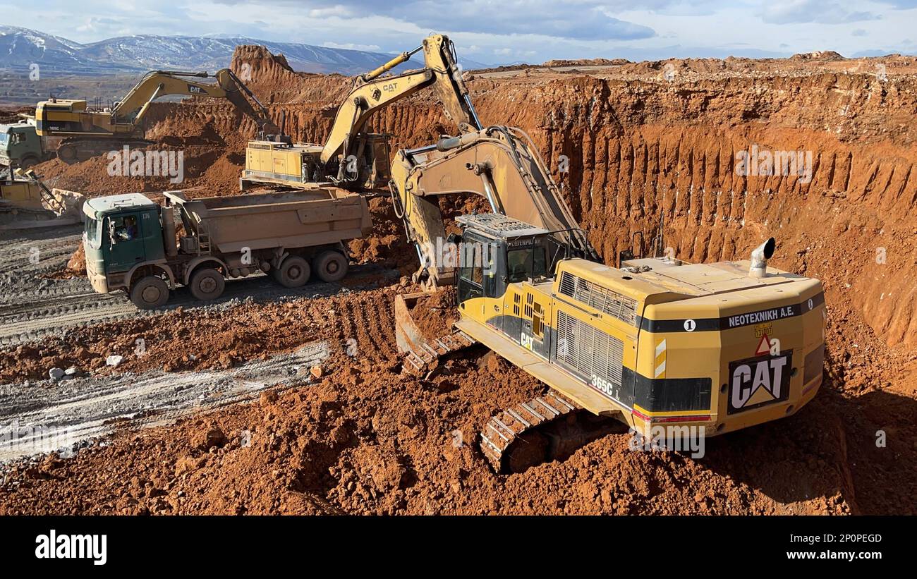 Excavators are loading continuously the trucks, working at a huge ...