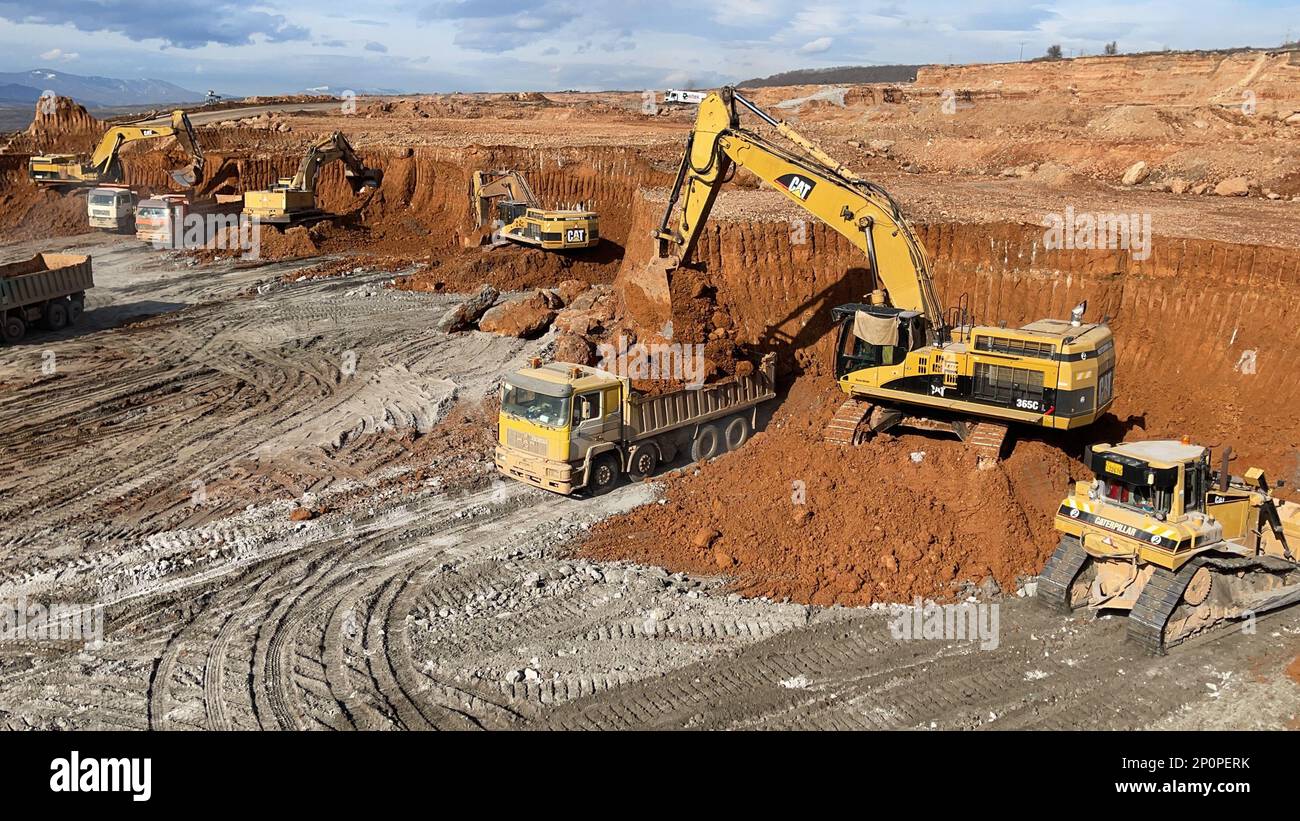 Excavators are loading continuously the trucks, working at a huge ...