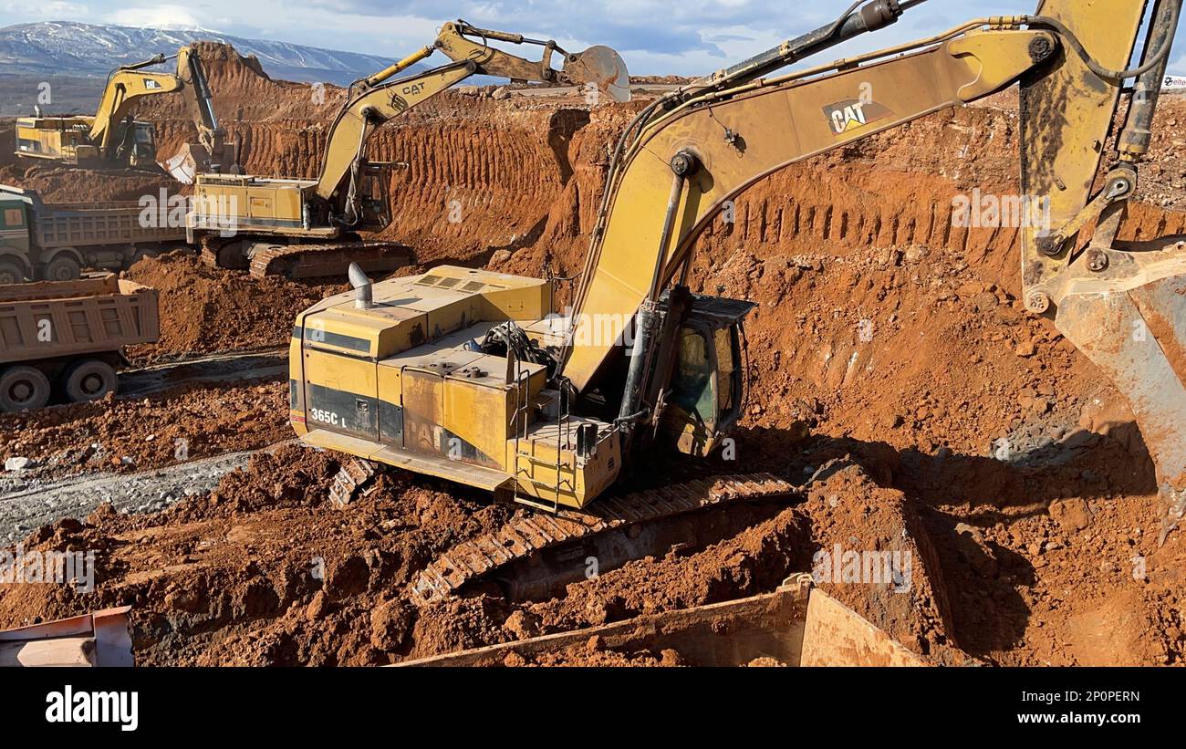 Excavators are loading continuously the trucks, working at a huge ...