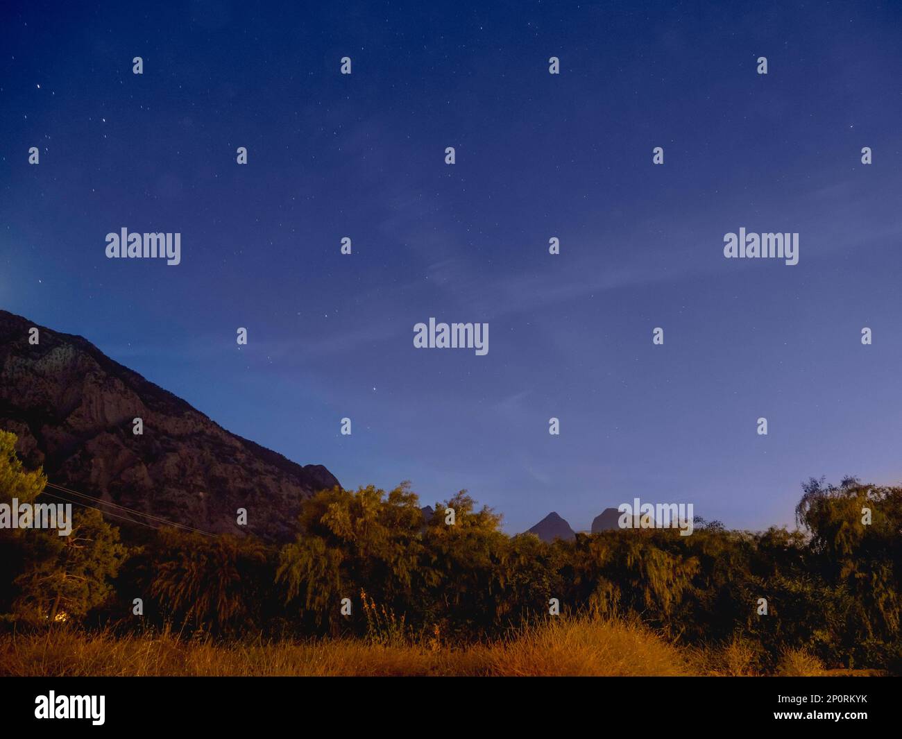 Traces of stars moving in the night sky upon mountains in Beldibi ...