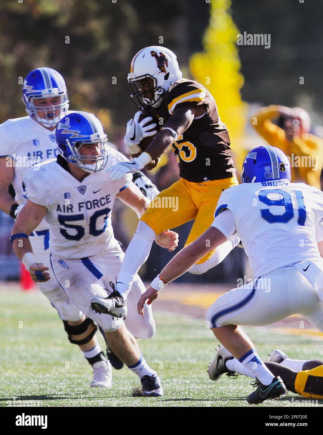 Wyoming wide receiver Austin Conway jumps in the air to avoid being ...
