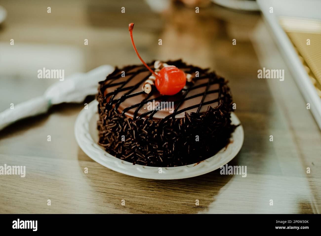 A freshly-baked chocolate cake with a ripe red cherry on top Stock ...