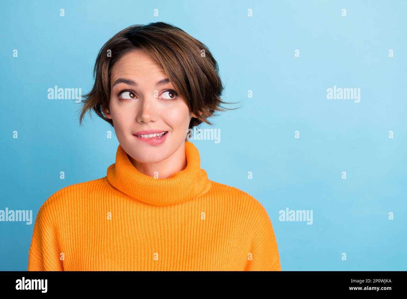 Photo of cheerful cute person biting lips look interested empty space ...