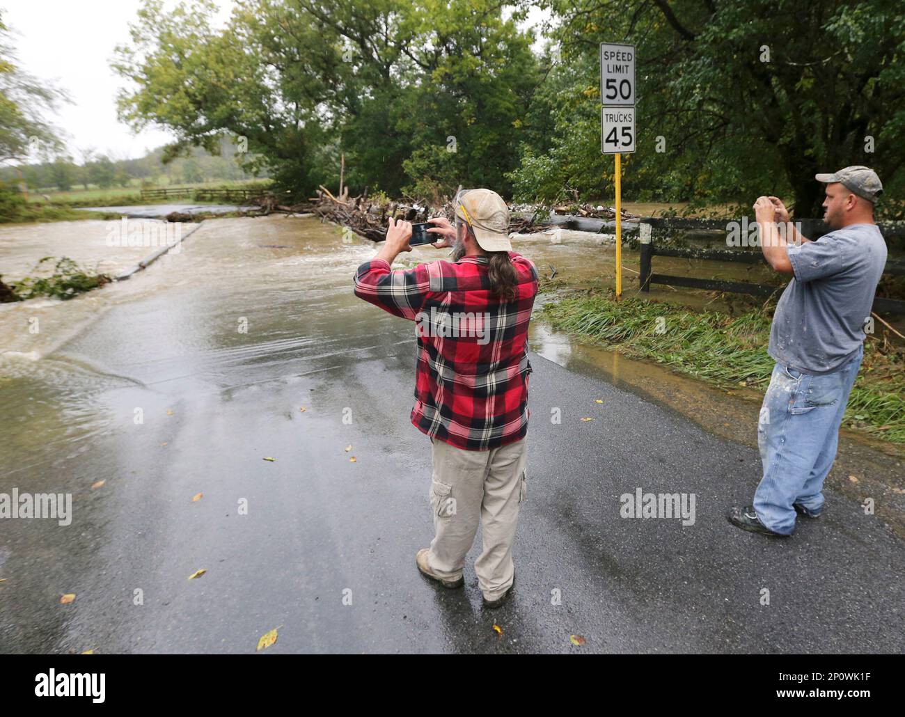 Paul Konopa, left, and J.R. Hines photograph flood water of the Opequon ...