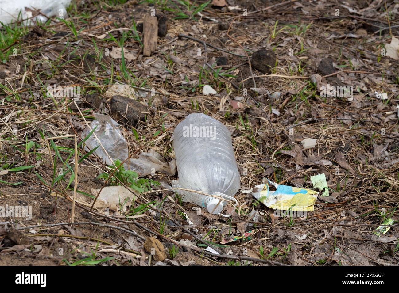 Spring forest stream river garbage waste plastic tire glass bottles after the snow melted ...
