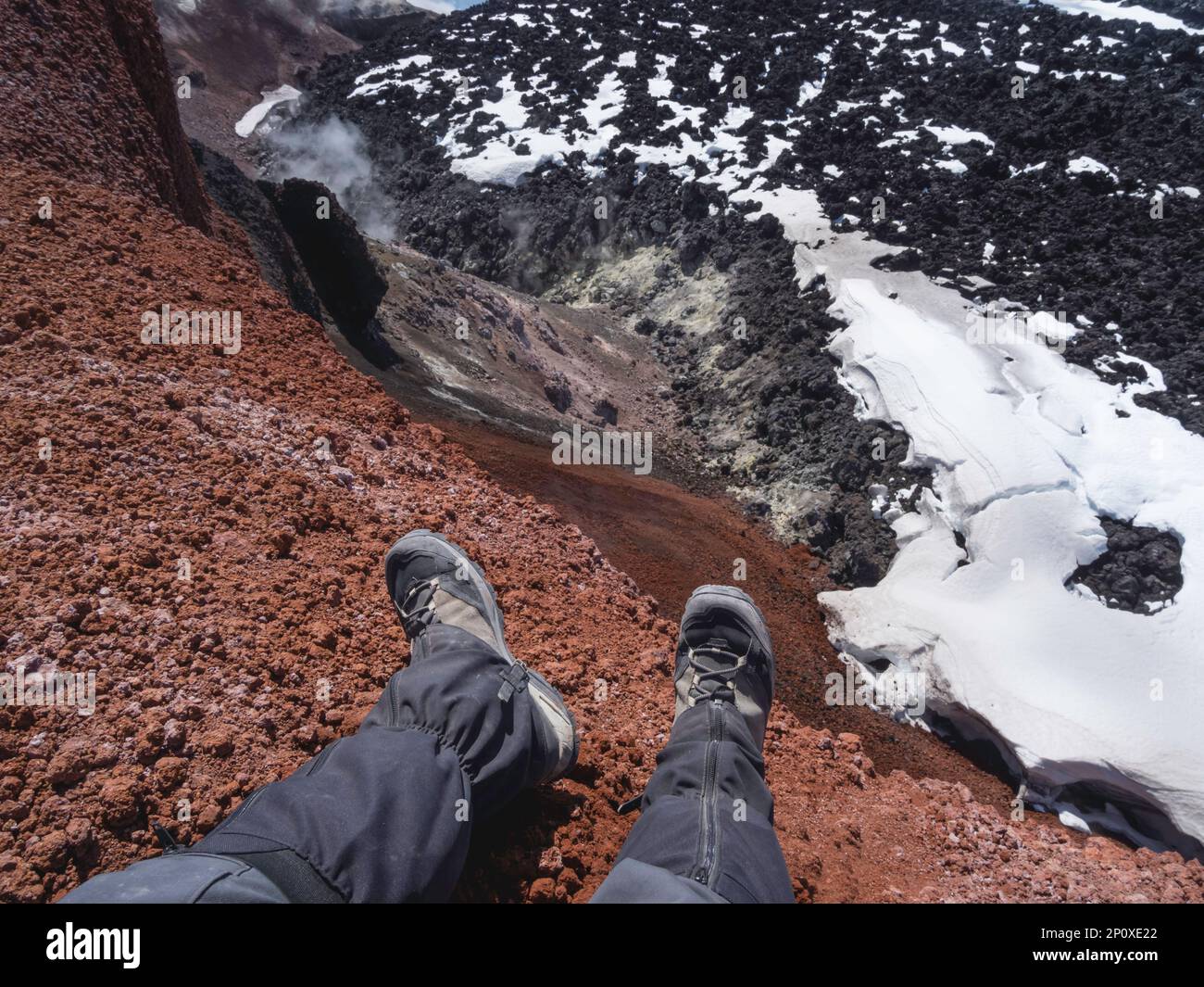 Top view on man's feet in hiking boots at caldera of Avachinsky ...