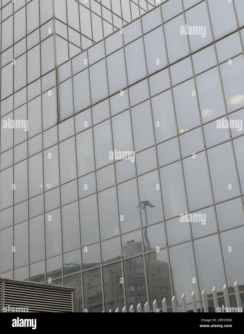 distorted reflection of apartment building in glass wall of skyscraper ...