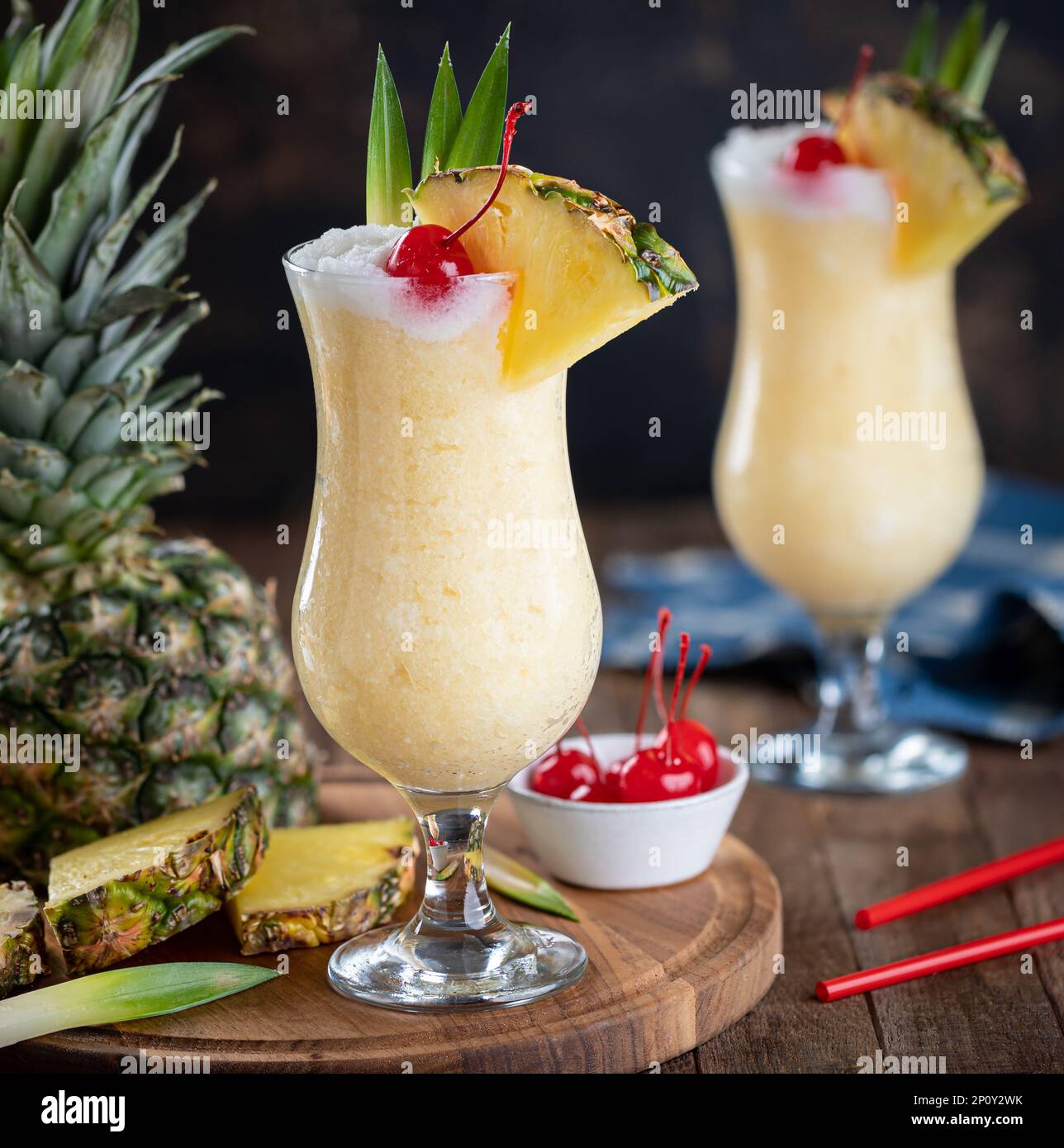 Pina colada cocktail garnished with cherry, pineapple slice and leaves ...