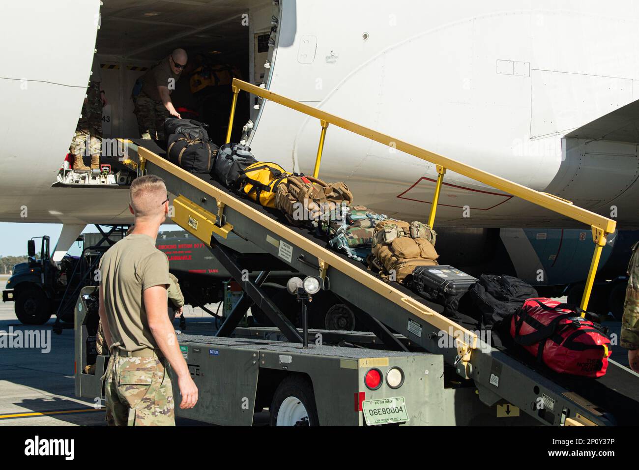 U.S. Air Force Airmen assigned to the 23rd Wing load their baggage at ...