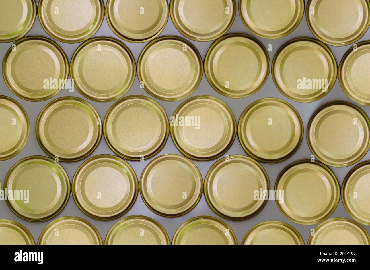A collection of neatly stacked tin cans stored in a metallic container ...