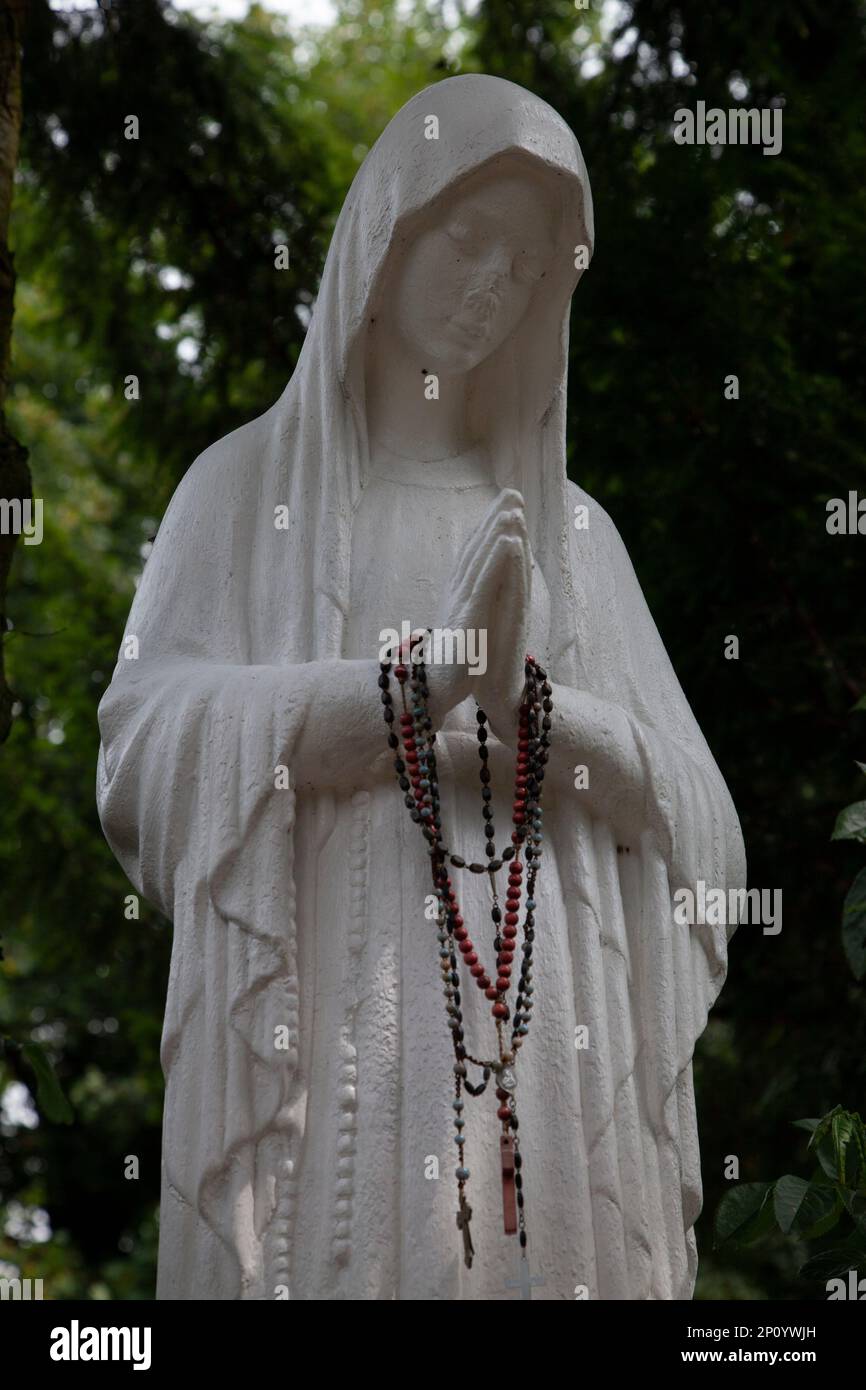 A statue of a woman in graveyard, grieving and praying with prayer ...