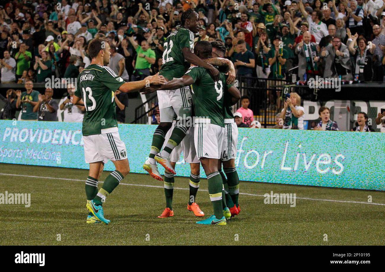 Portland Timbers players swarm Fanendo Adi (9) after he scored a goal in the first half during a ...
