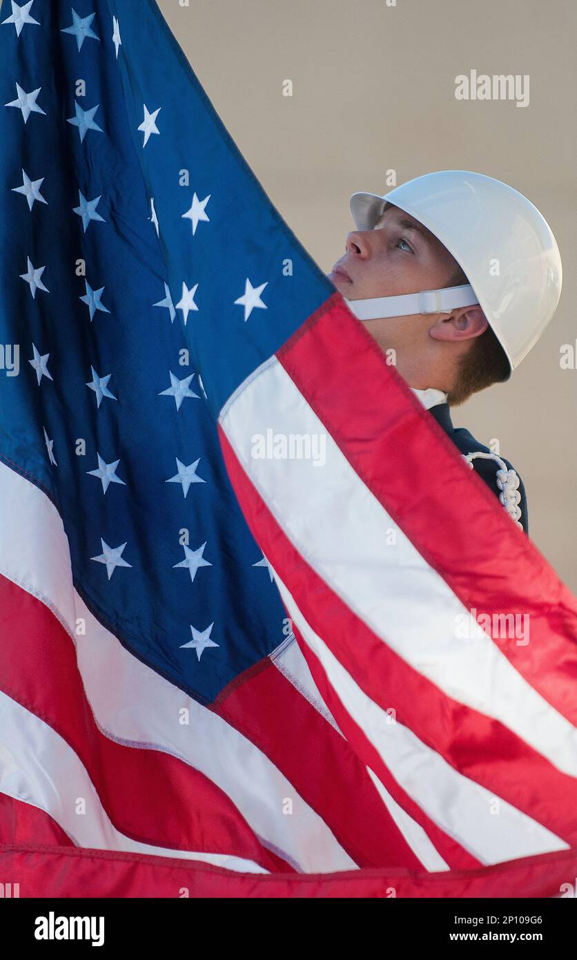A member of The Academy for Academic Excellence's color guard hoists ...