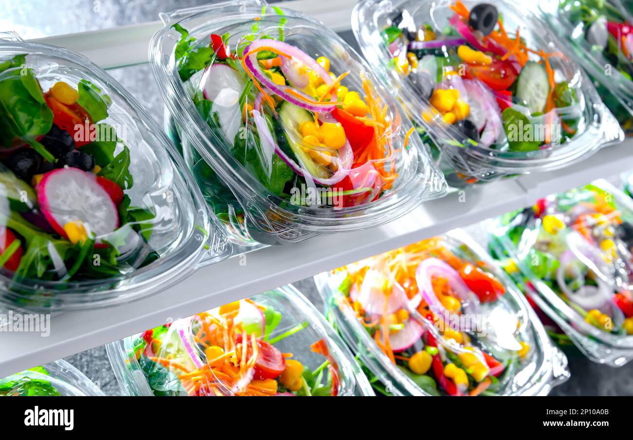 Plastic boxes with pre-packaged vegetable salads, put up for sale in a ...