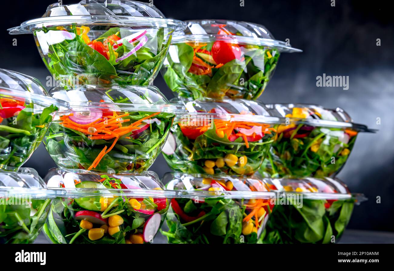Plastic boxes with pre-packaged vegetable salads, put up for sale in a ...