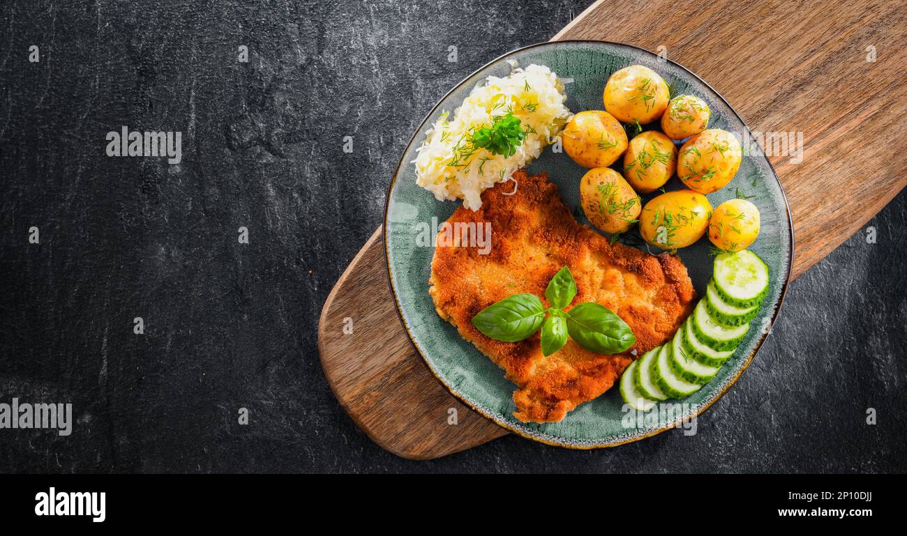 Pork breaded cutlet coated with breadcrumbs served with potatoes and ...