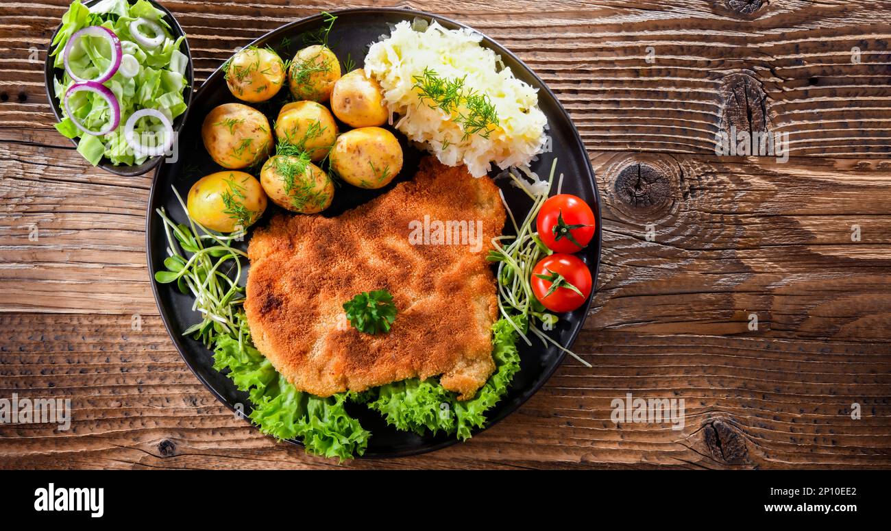 Pork breaded cutlet coated with breadcrumbs served with potatoes and ...