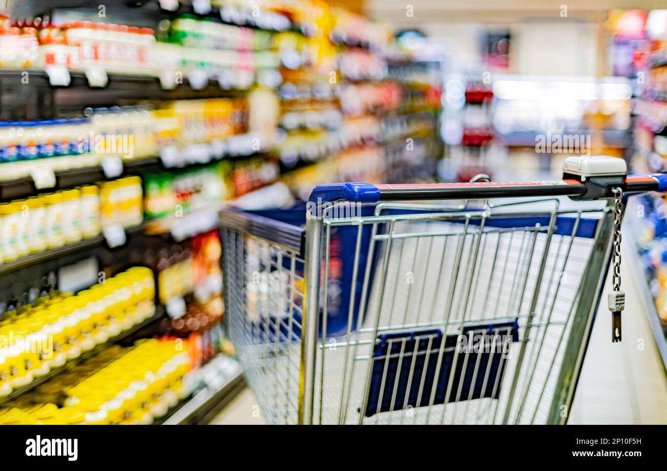 A shopping cart by a store shelf in a supermarket Stock Photo - Alamy