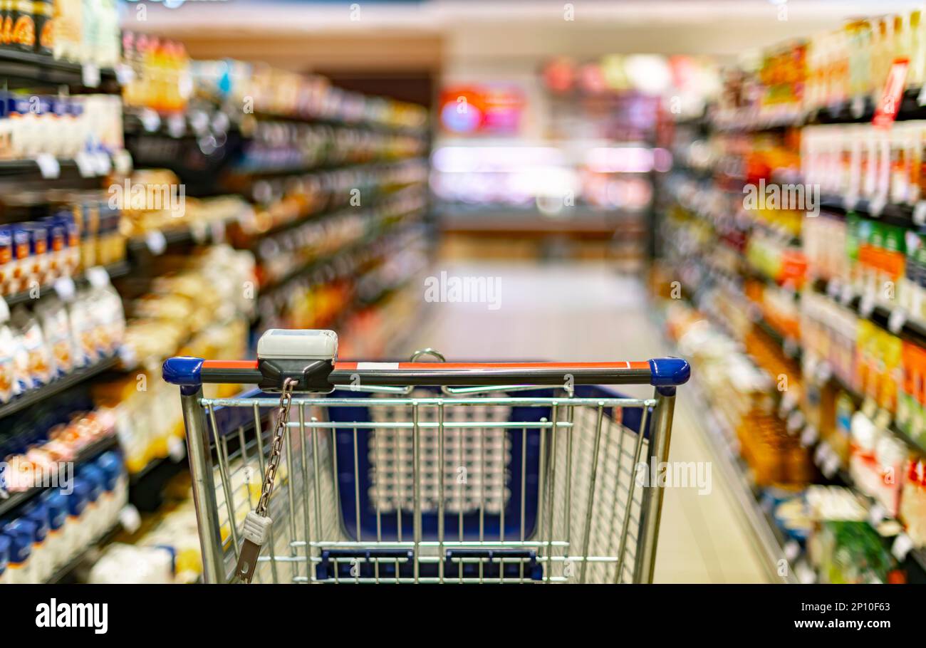 A shopping cart by a store shelf in a supermarket Stock Photo - Alamy
