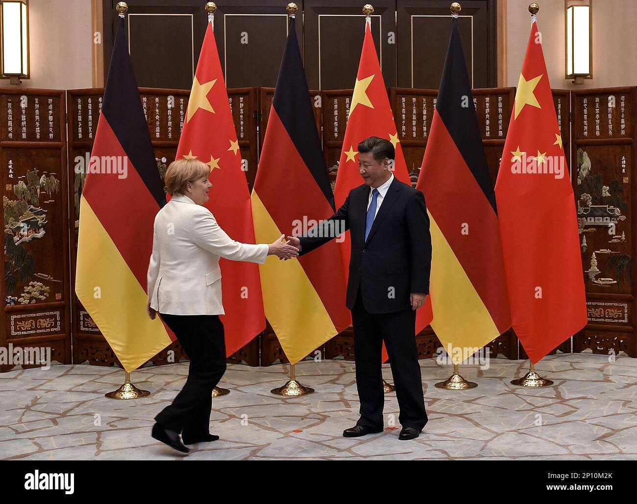 Chinese President Xi Jinping, right, shakes hand with German Chancellor ...
