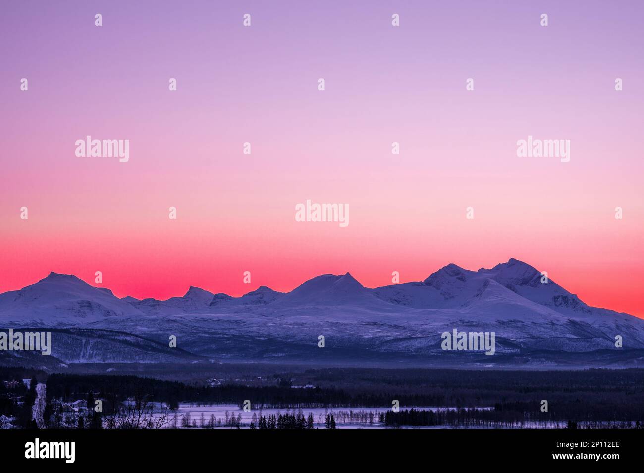 A majestic snow-capped mountain peaks silhouetted against a vibrant sunset sky Stock Photo - Alamy