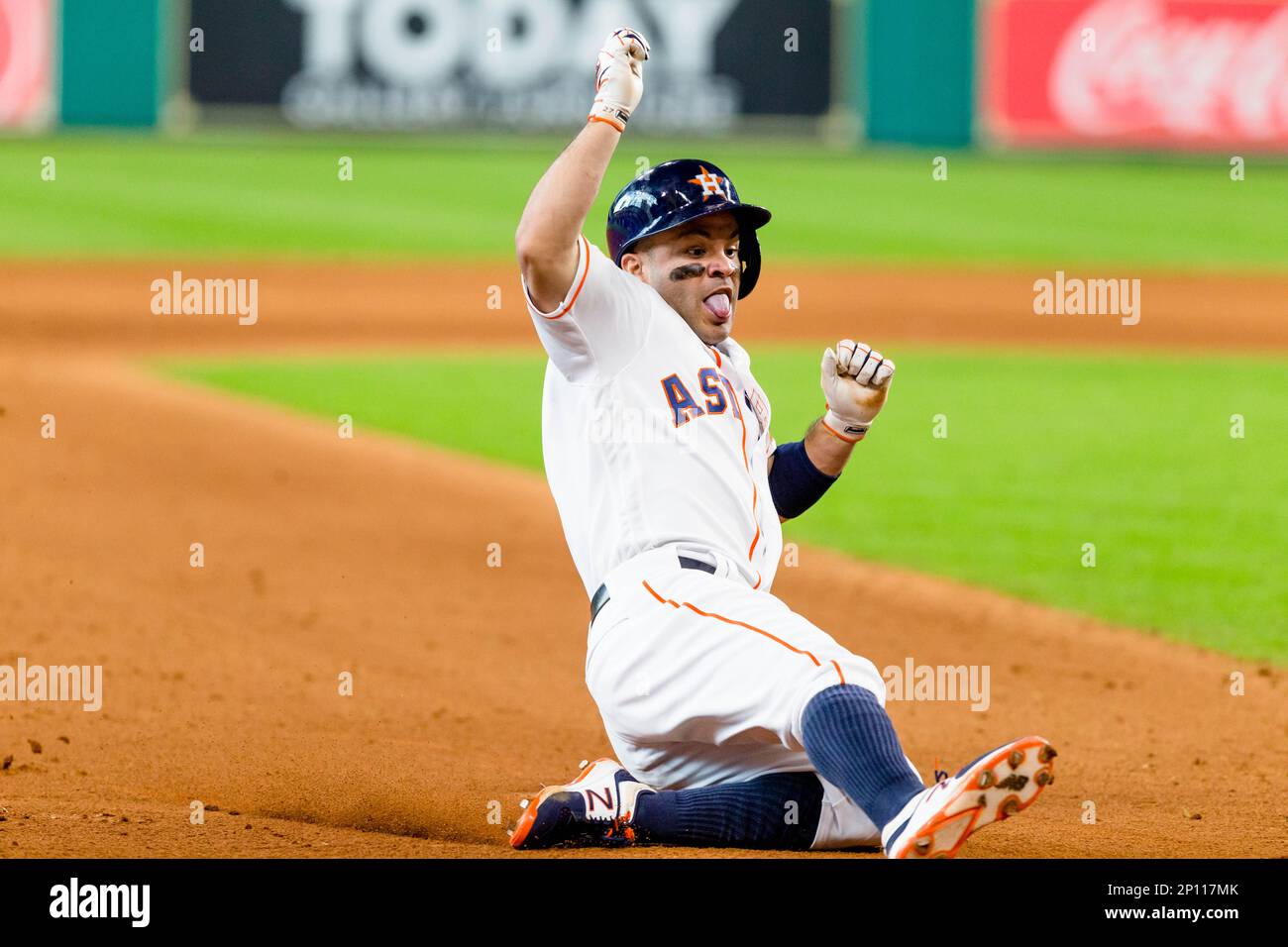 Houston Astros second baseman Jose Altuve (27) slides into third base on a line drive triple to ...