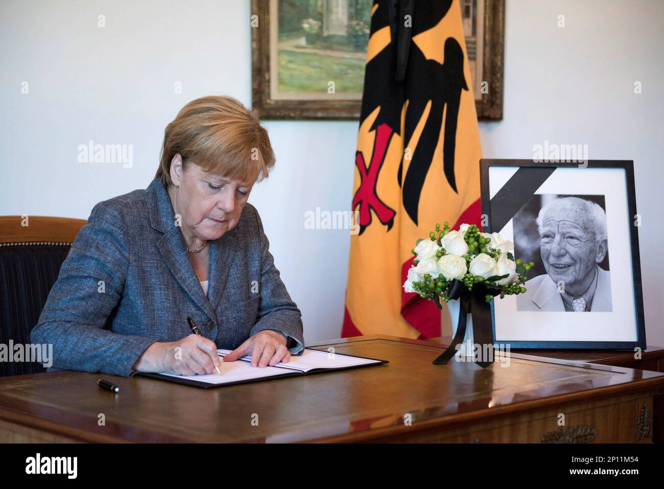 German Chancellor Angela Merkel signs the condolence book for former ...
