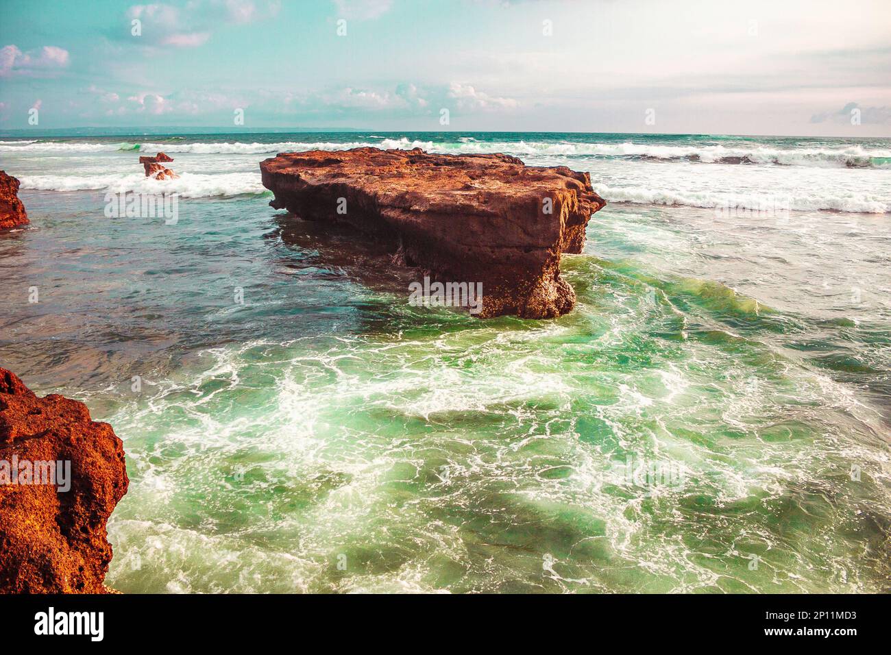 Rocks and cliffs among waves near Bali island coastline, Indonesia. A ...