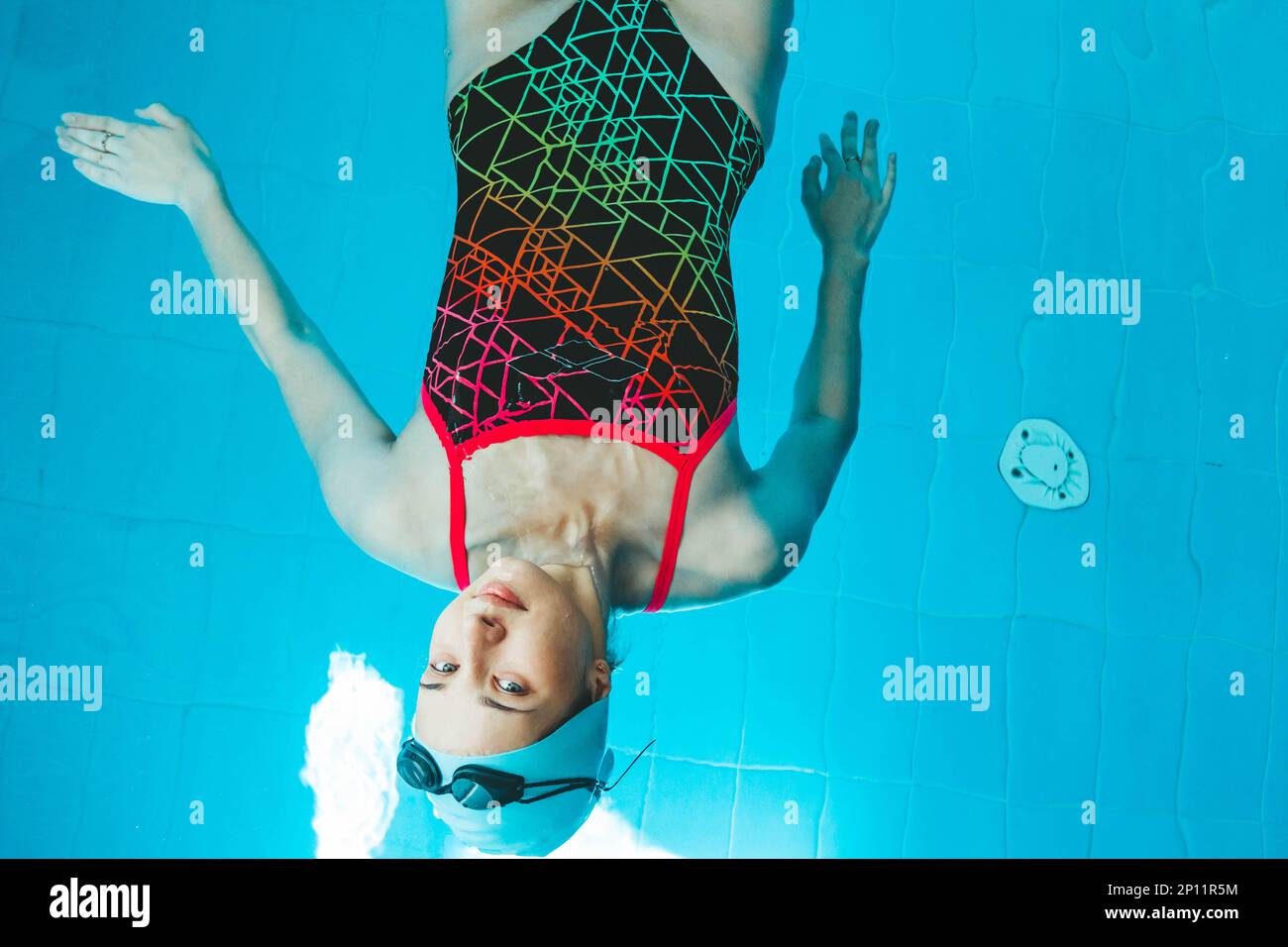 Top view of a young female swimmer training in the pool, swimming on ...