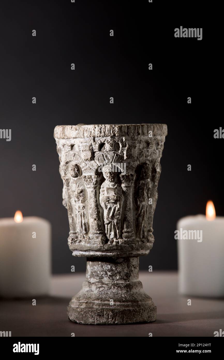stone christian chalice with burning candles on gray altar black ...
