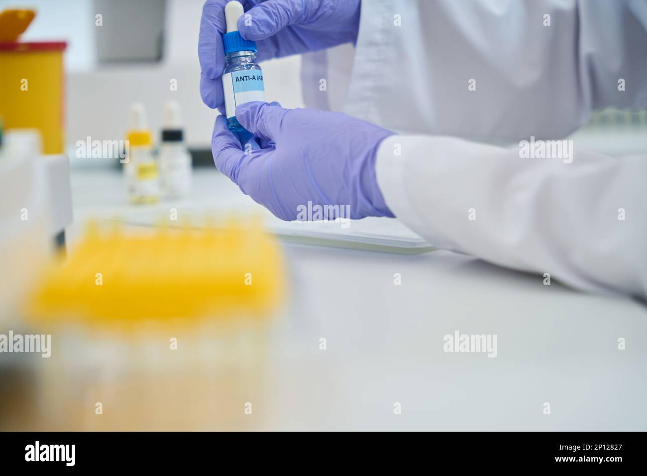 Liquid in a bottle with a blue cap in the hands of a laboratory ...