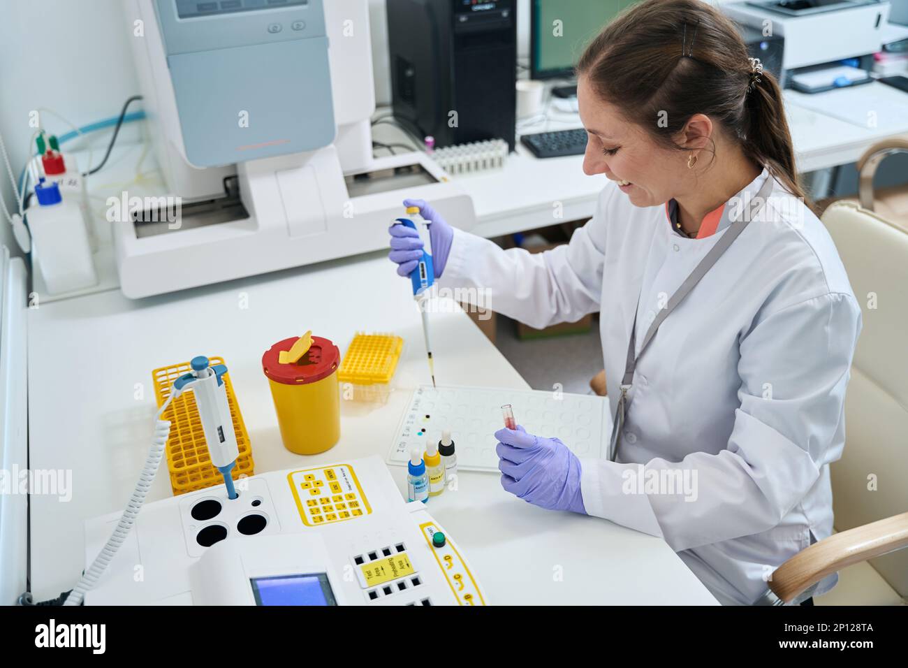 Female laboratory assistant conducts blood group test in testing unit ...