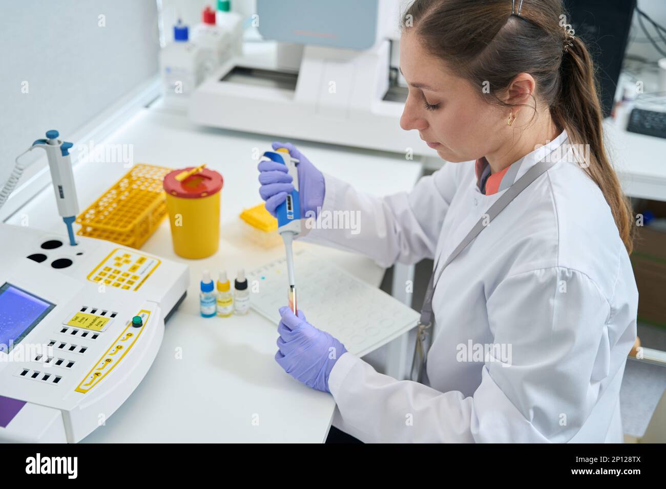 Female laboratory assistant uses special pipette to work with ...