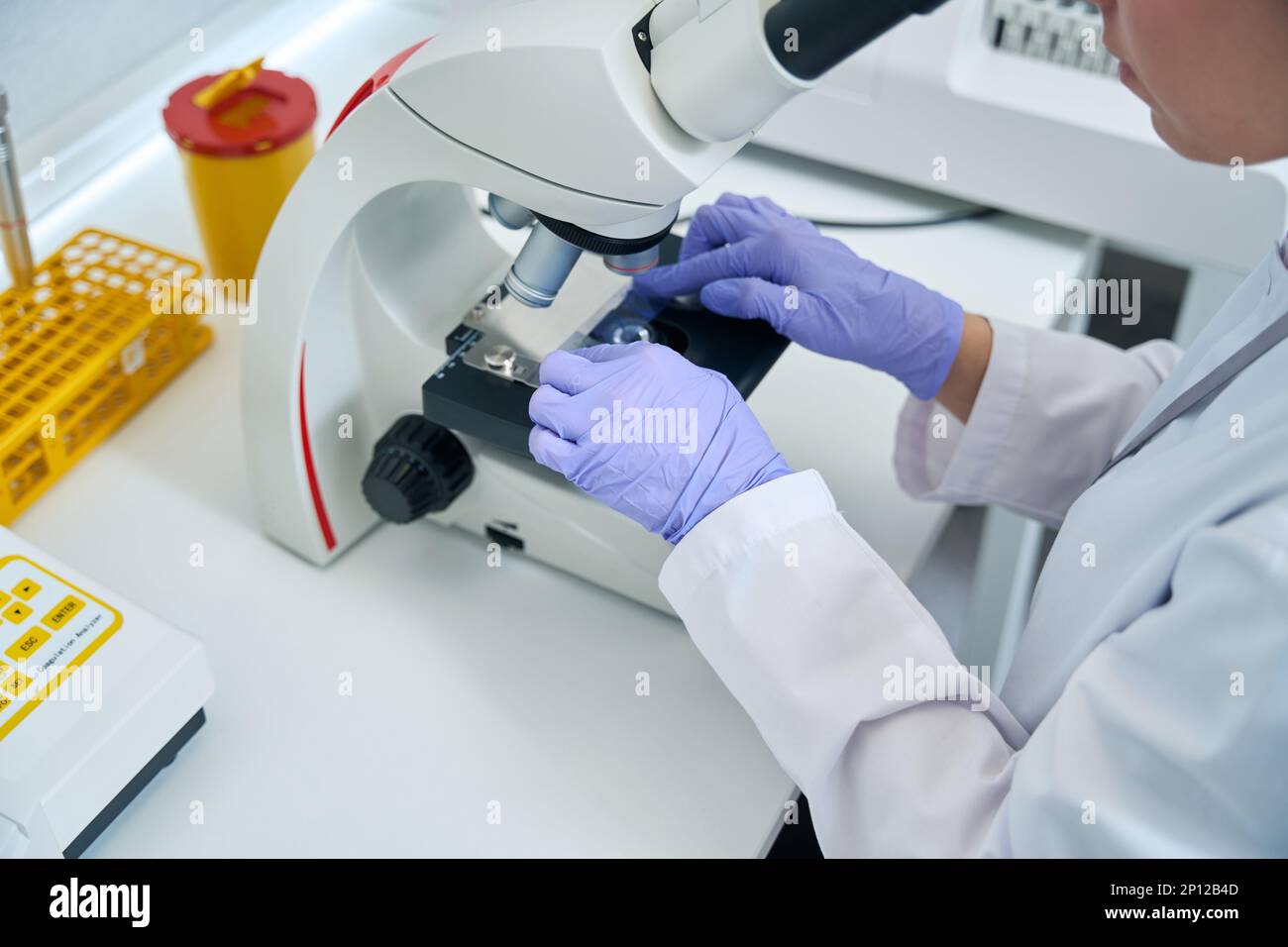 Female laboratory assistant examinesa sample of biomaterial for DNA ...