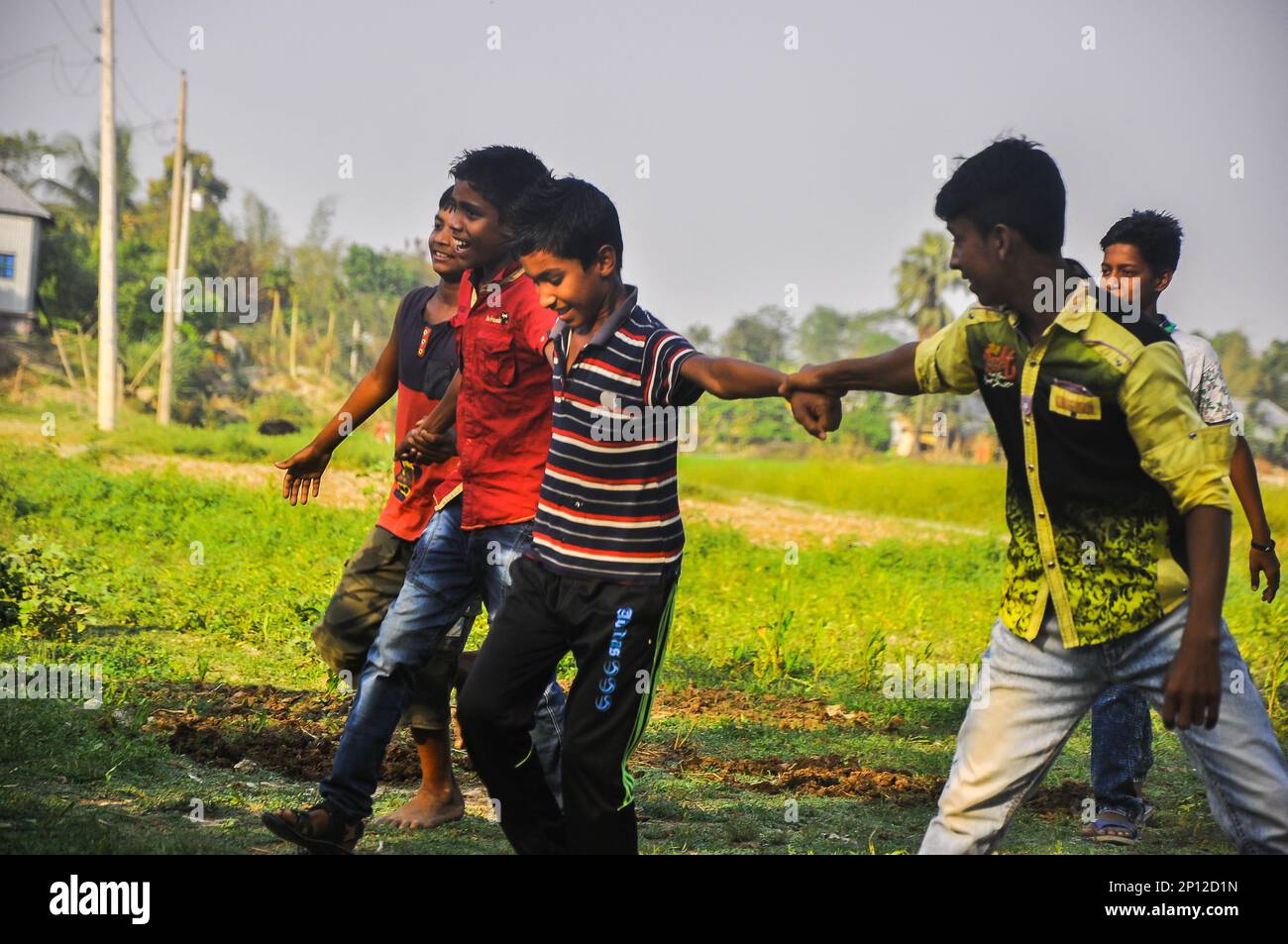 Some children playing traditional games in an open fiend in a village ...