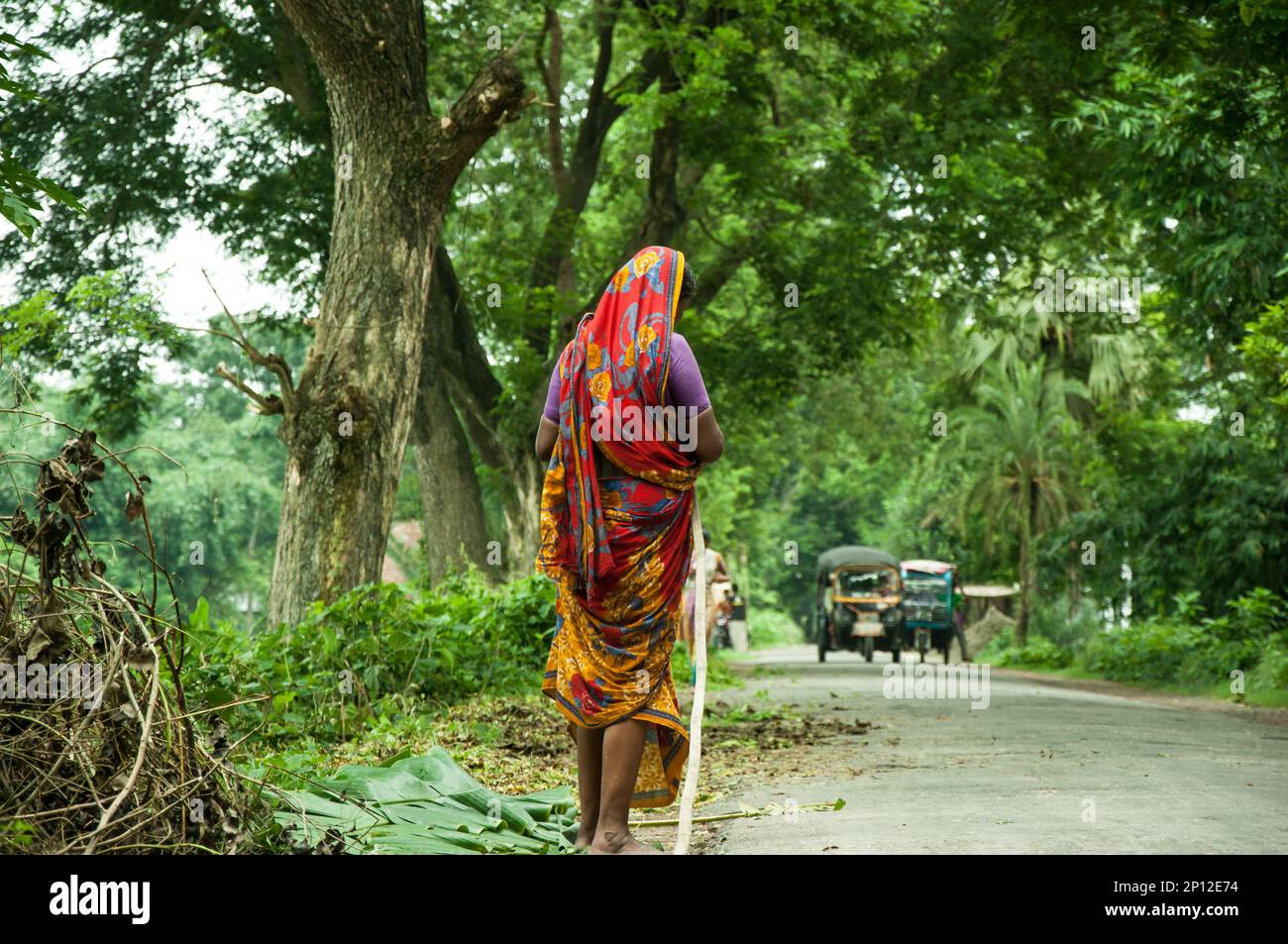 Picture of a poor woman worker working in a street in Faridpur ...