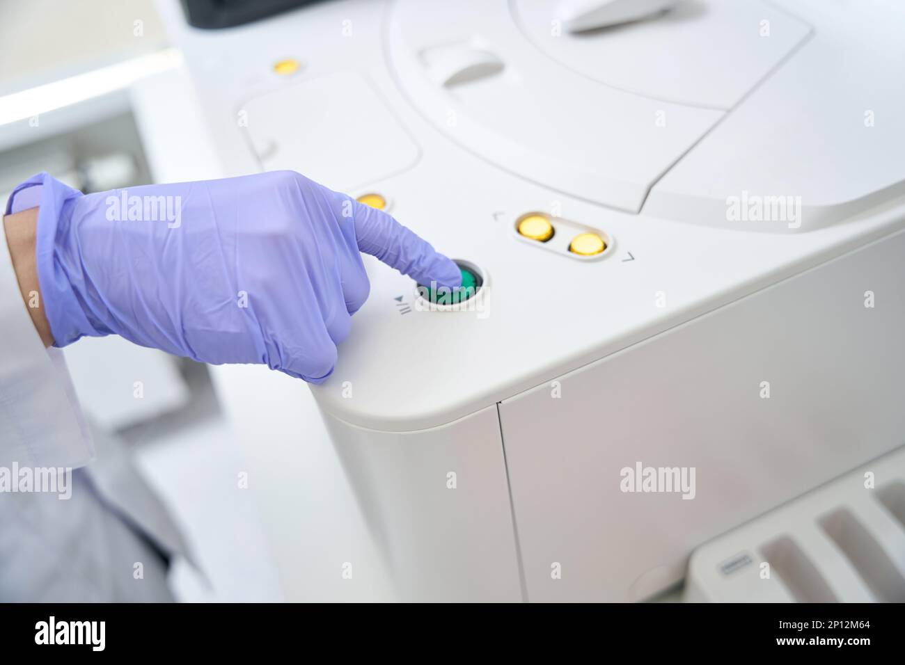 Laboratory assistant presses the button on immunochemiluminescent ...