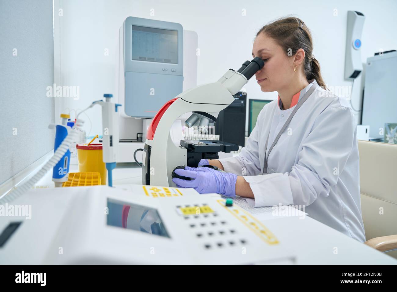 Laboratory employee looks into the eyepiece of microscope Stock Photo ...