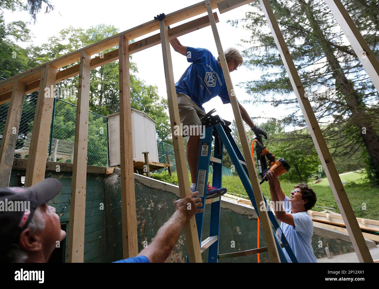 Sandy Clapp reaches down to get the nail gun from Terry Smith while ...