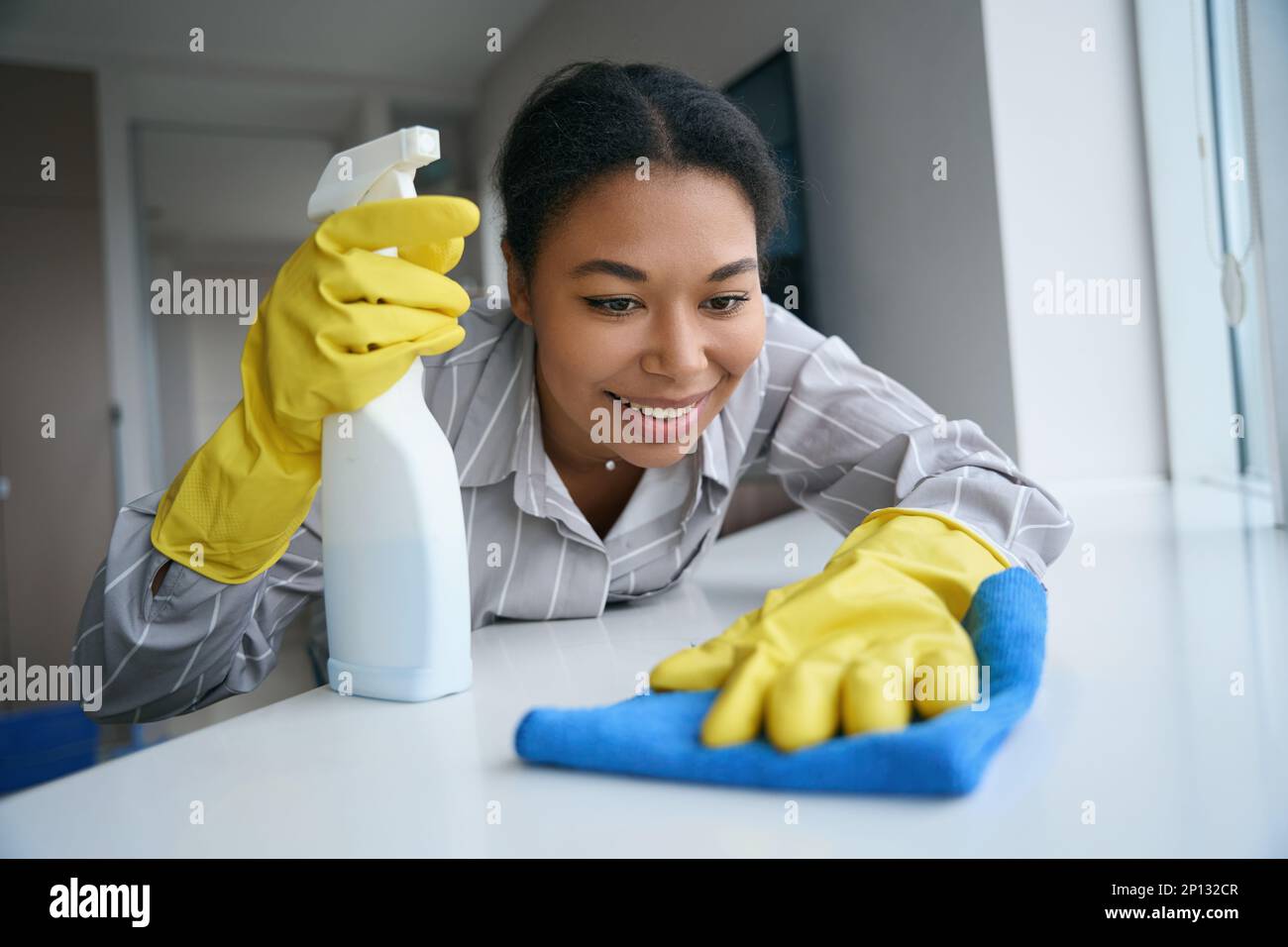 Happy african american female cleaning surface with rag Stock Photo - Alamy