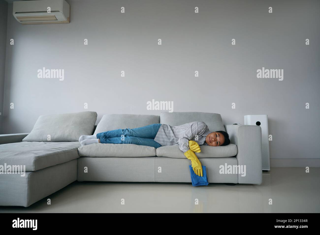 Little tired female lay down to rest on soft sofa Stock Photo - Alamy