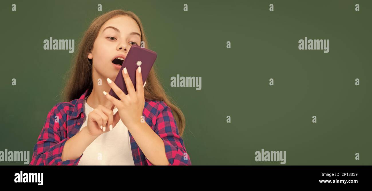 happy teen girl talking on mobile phone in high school at blackboard ...