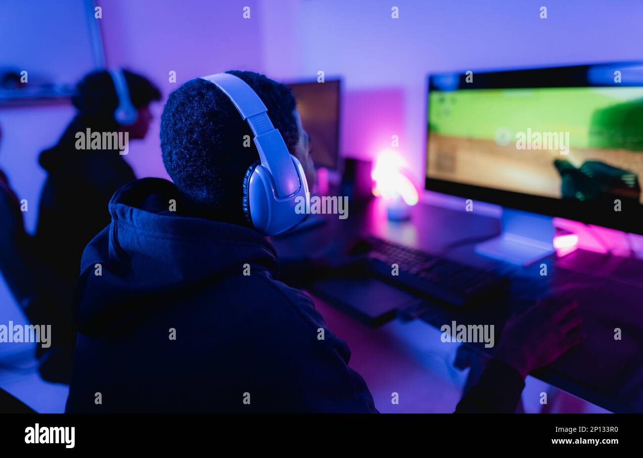 Young gamers having fun playing online video games with computer at ...