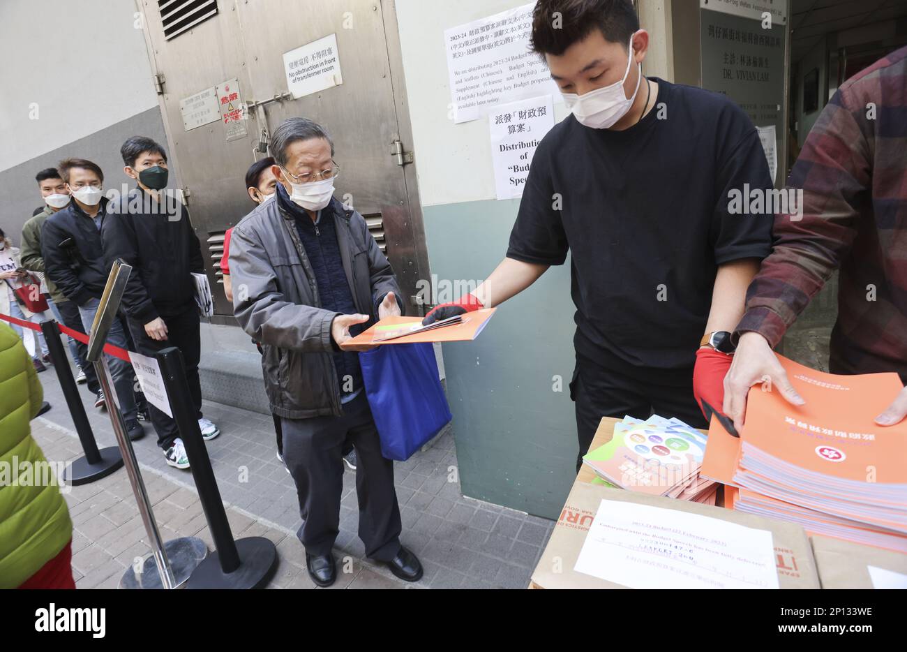 People queue up to receive a copy of the Budget Speech and a leaflet ...