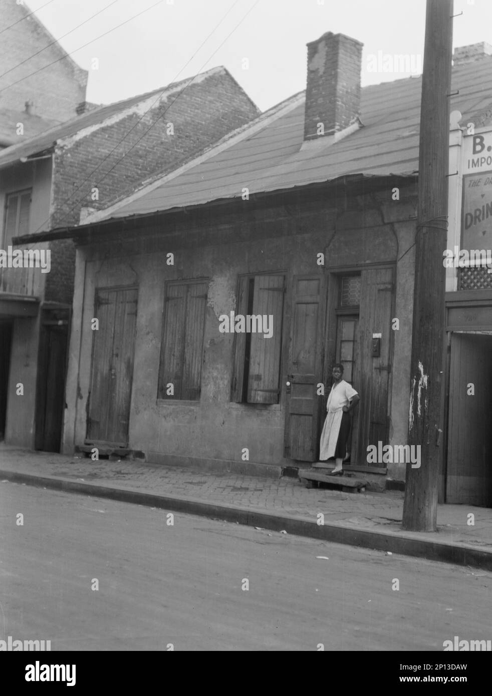 View from across street of a woman standing by a doorway in the French ...
