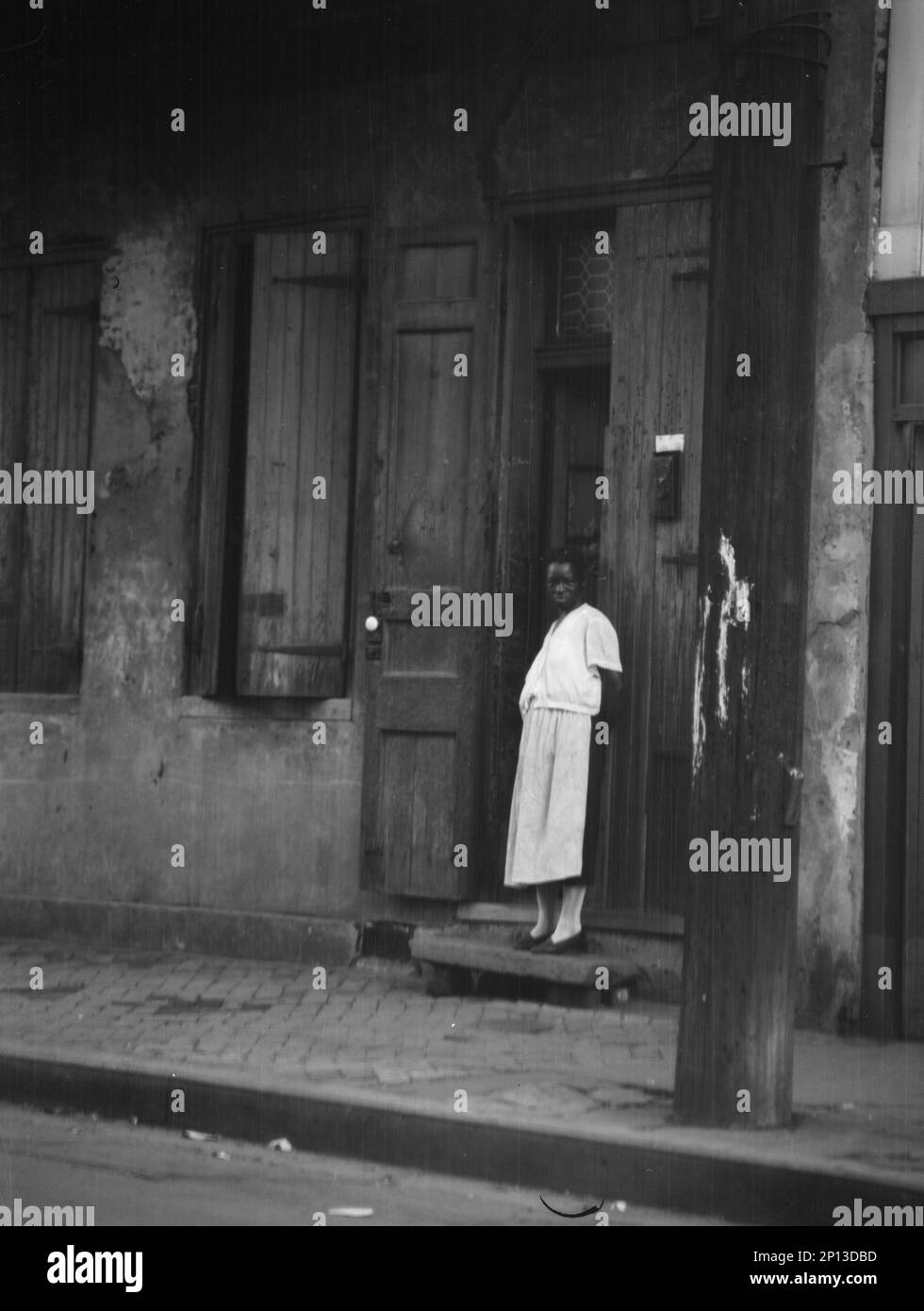 View from across street of a woman standing in a doorway in the French ...