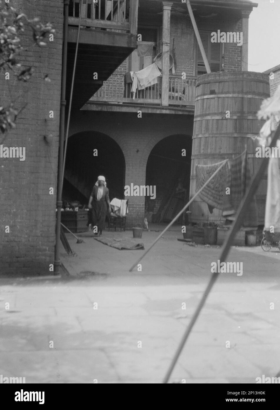 Courtyard with cistern and woman cleaning, New Orleans, between 1920 ...